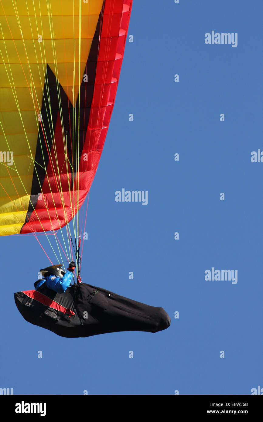 Paraglider pilots soaring against blue sky Stock Photo - Alamy
