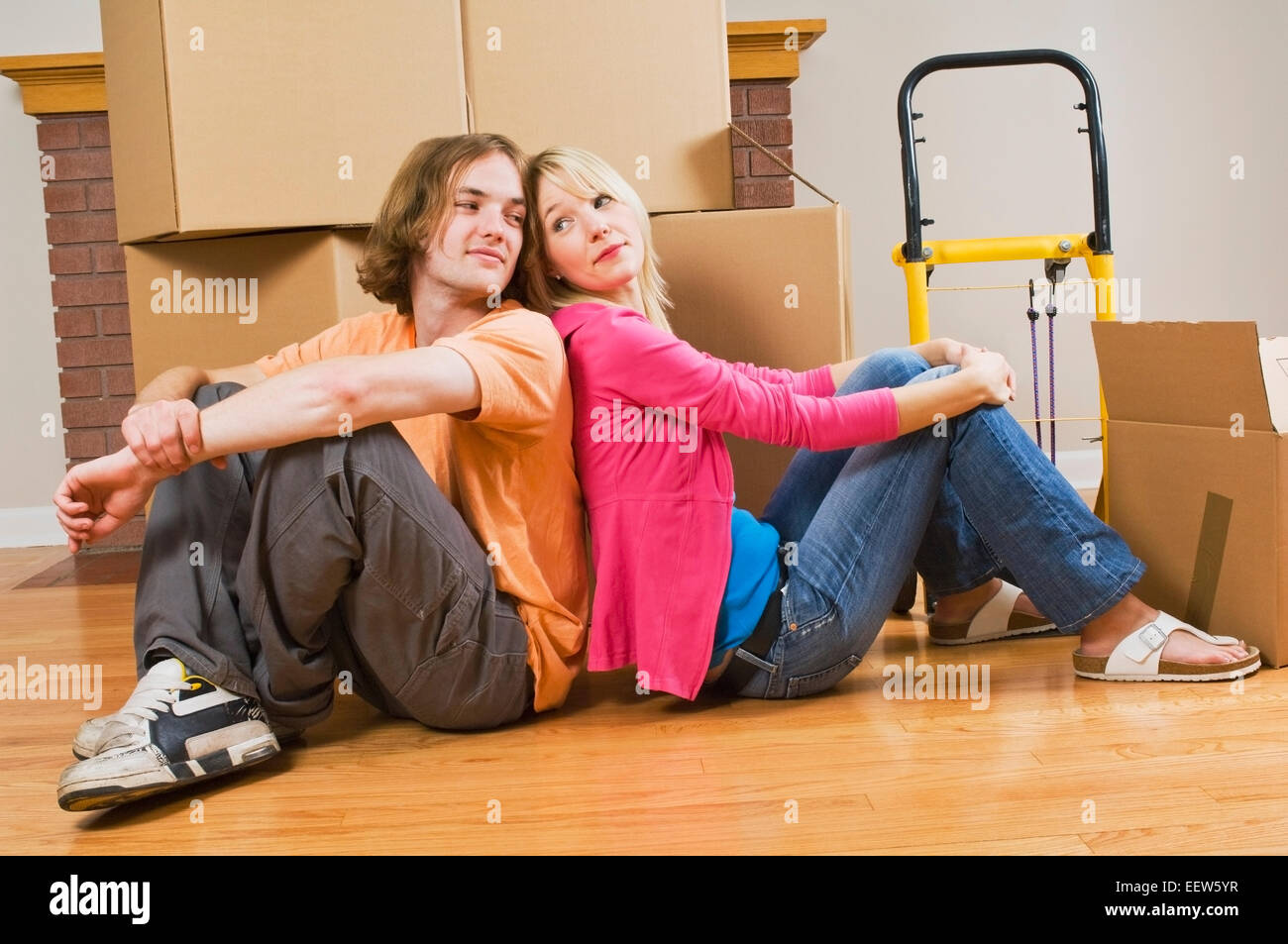 Two people sitting in front of boxes Stock Photo - Alamy