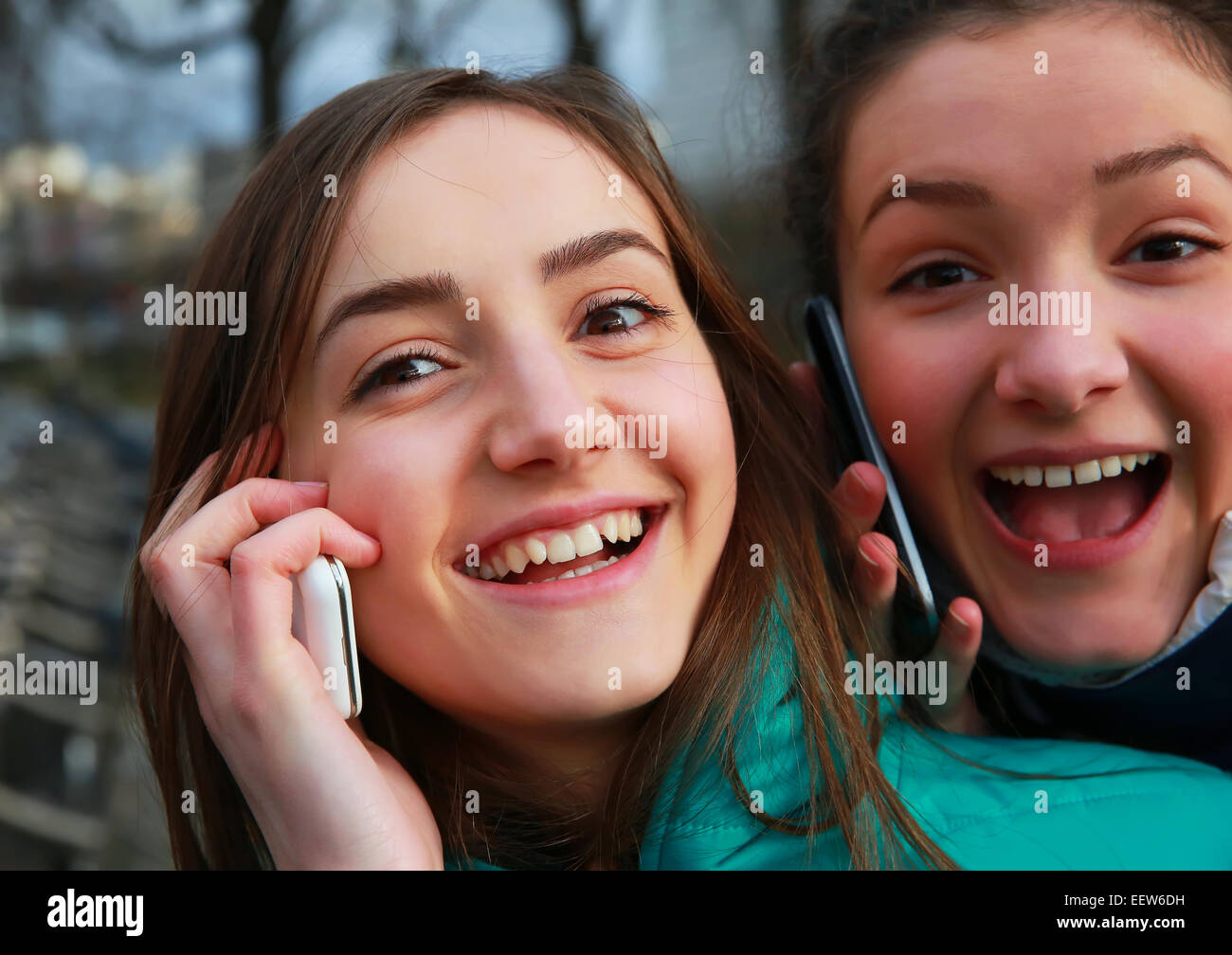 Girls with a mobile phones having fun outside Stock Photo - Alamy