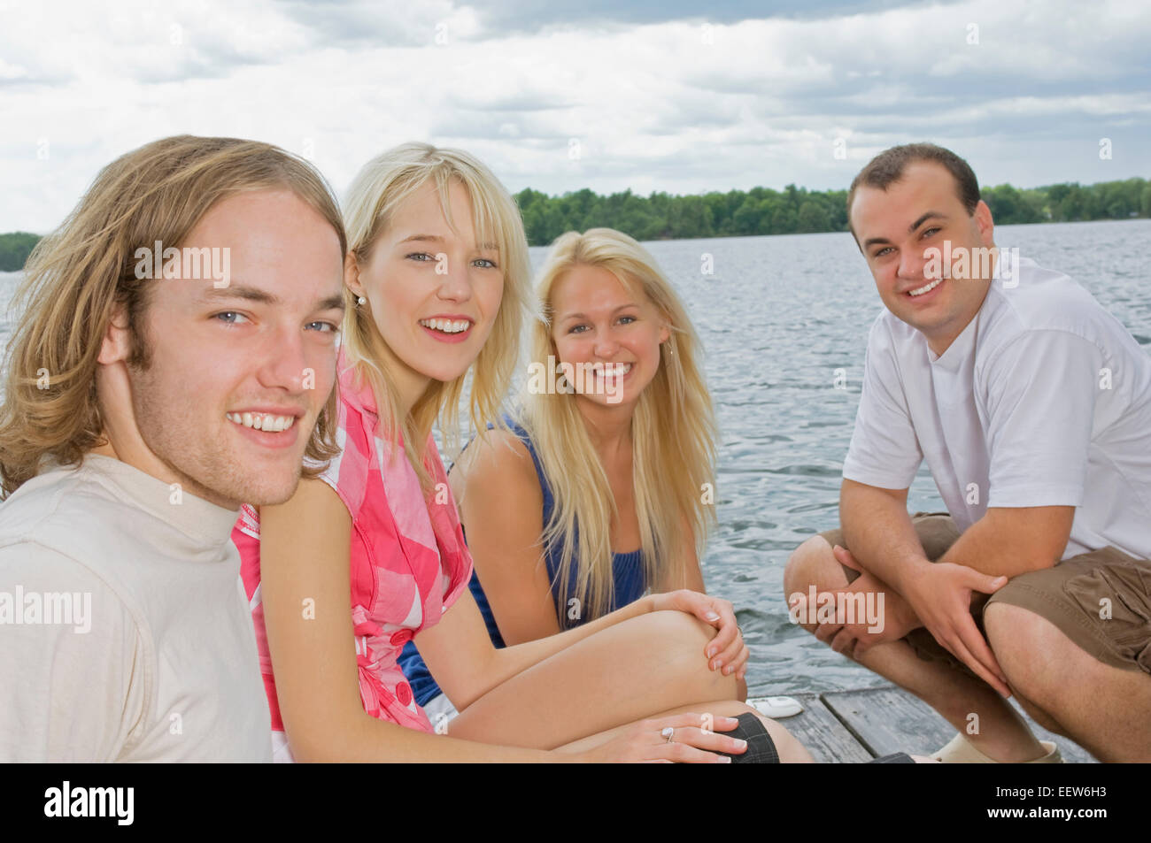 Four people on a dock surrounded by water Stock Photo - Alamy