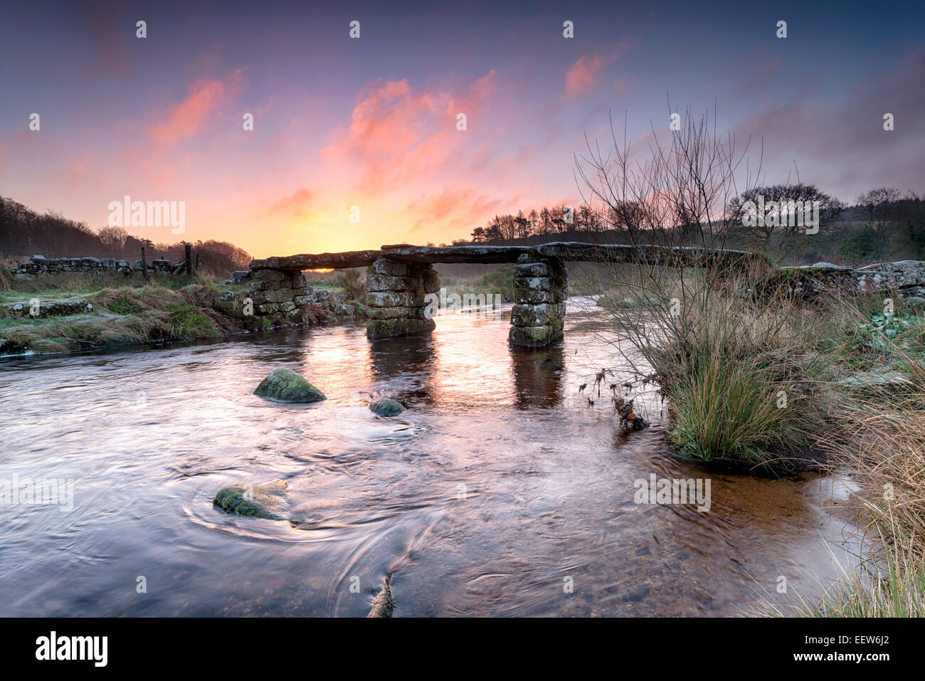 An ancient stone clapper bridge over the East Dart river at Postbridge ...