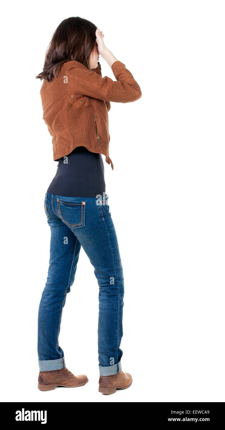 Back view of shocked woman in blue jeans. girl hid his eyes behind his ...