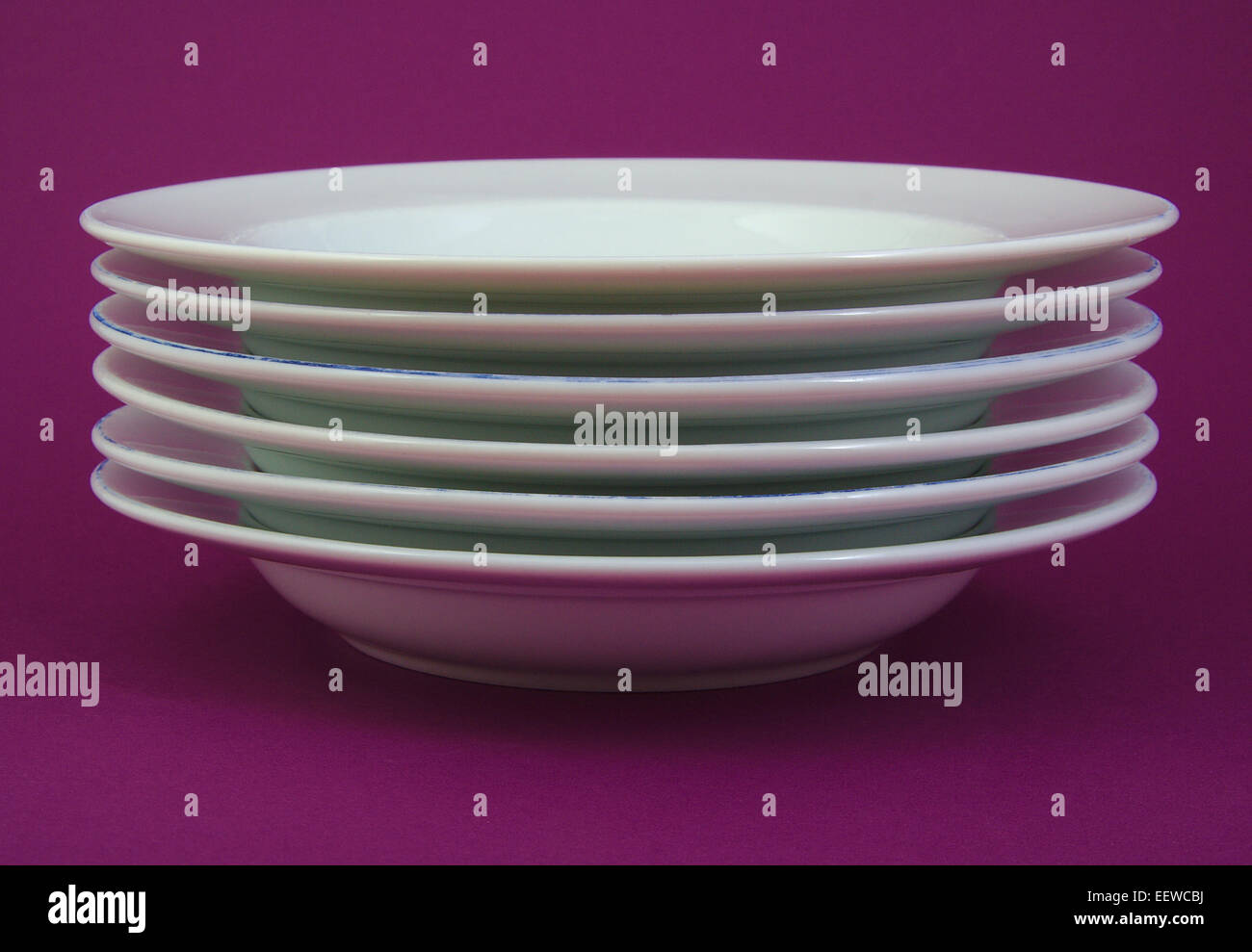 Stack of white and used dishes on purple background Stock Photo - Alamy
