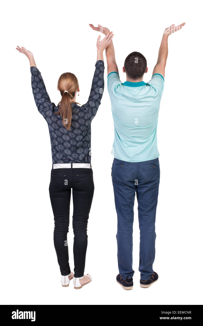 Back view couple looking at wall and Holds hand up. Rear view people ...