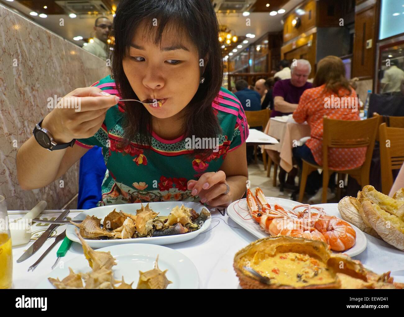 Girl eating in seafood restaurant Stock Photo - Alamy