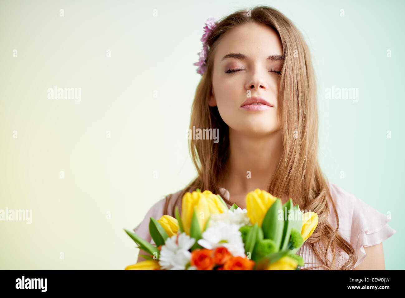 Attractive girl enjoying smell of spring flowers Stock Photo - Alamy