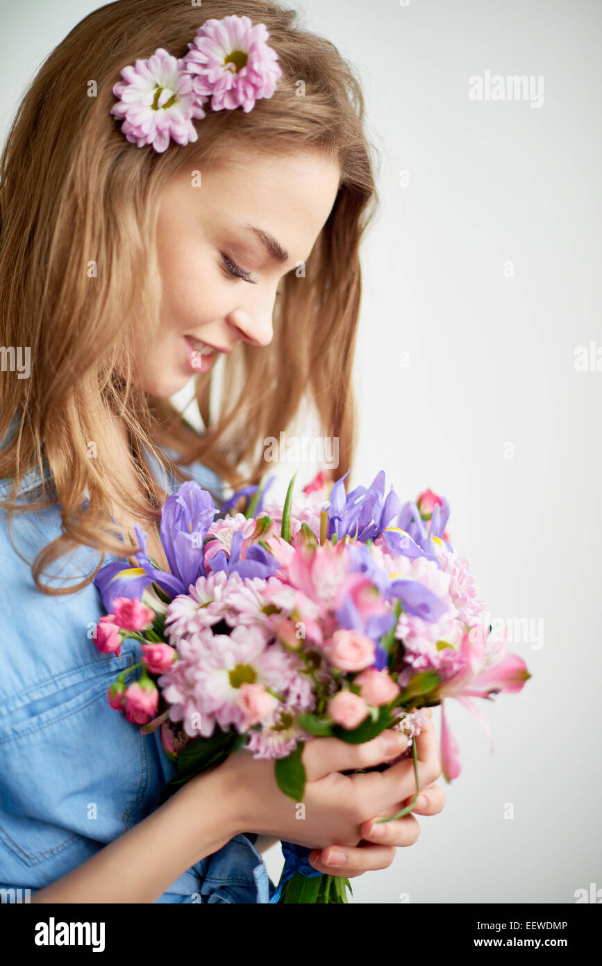 Beautiful girl looking at bunch of flowers Stock Photo - Alamy