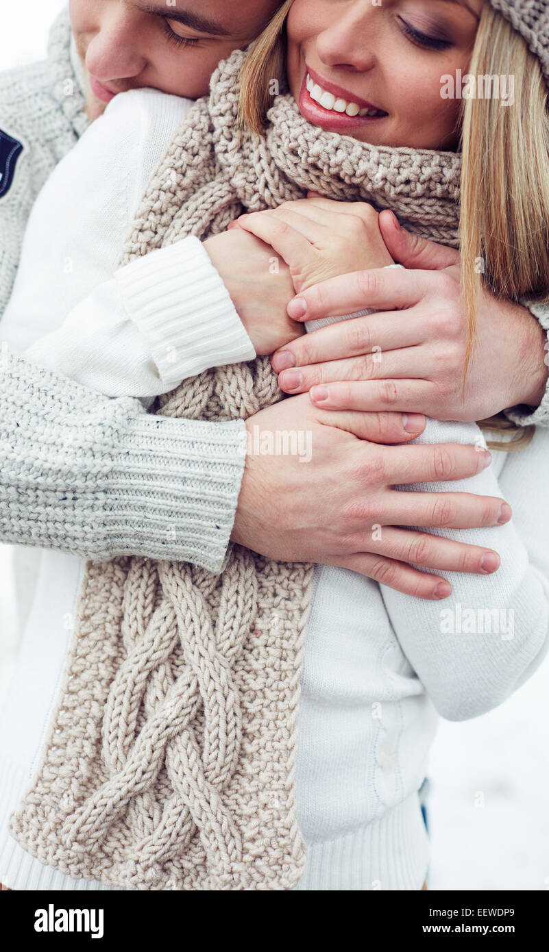 Tender man embracing happy girlfriend in winterwear Stock Photo - Alamy
