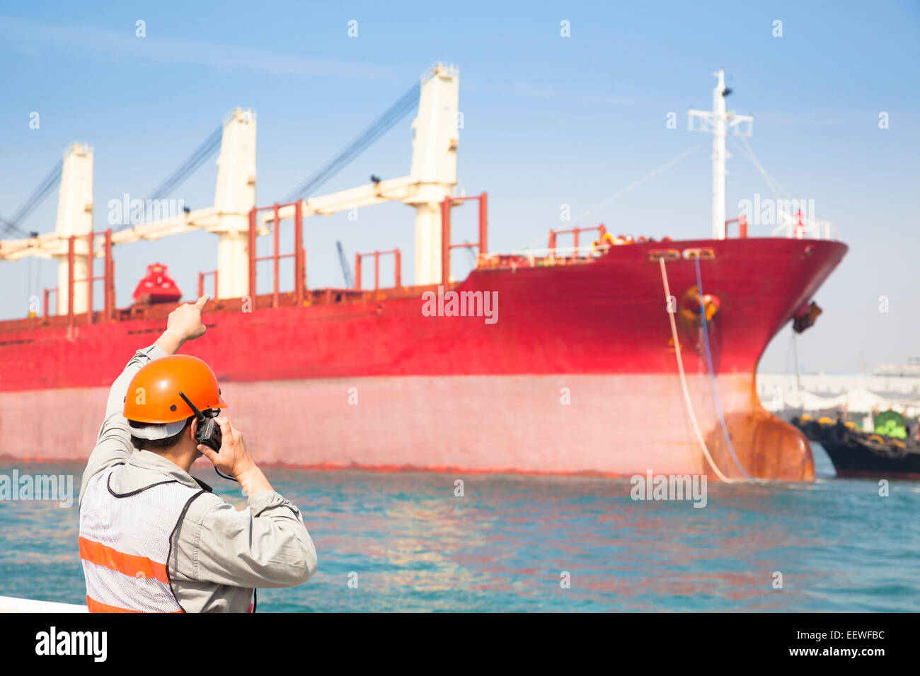 Harbor dock worker talking on radio with ship background Stock Photo ...