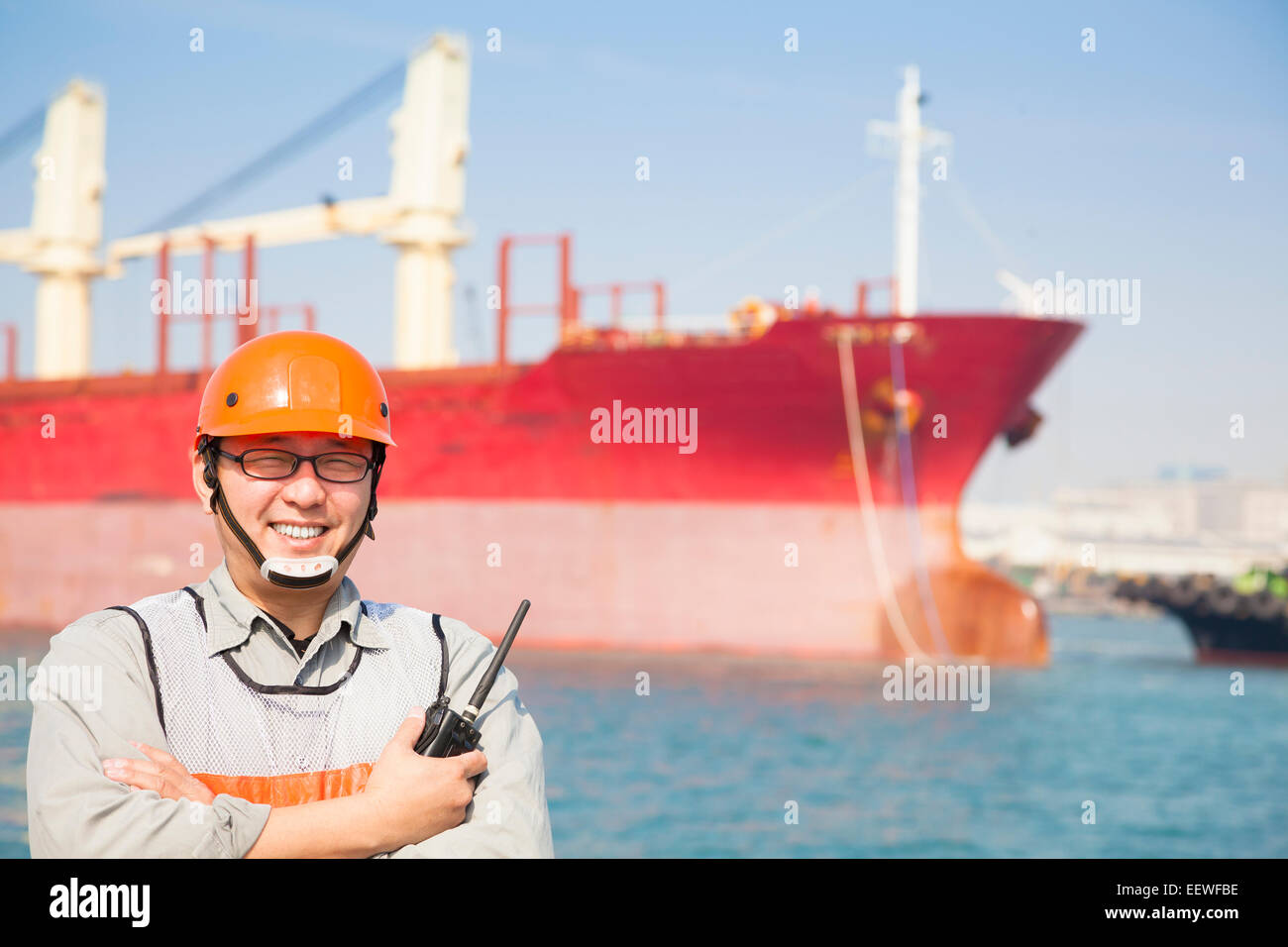 Harbor dock worker tholding radio and ship background Stock Photo - Alamy
