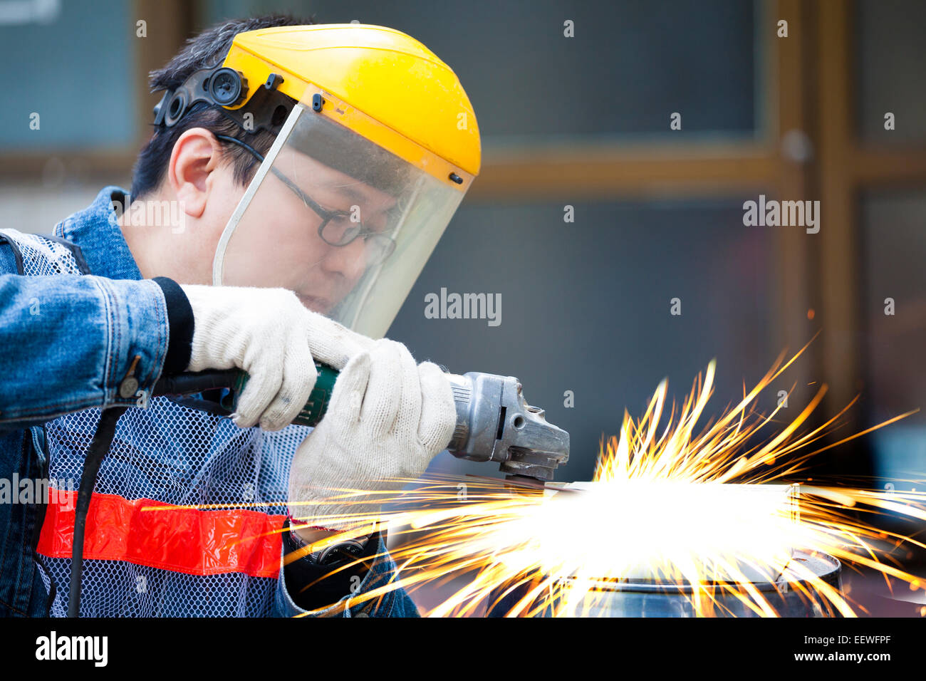 worker with grinder machine cutting metal in factory Stock Photo - Alamy
