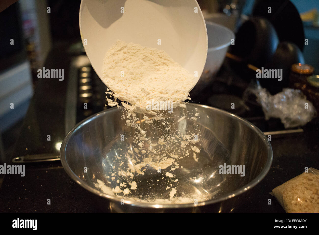 Pouring flour from a plastic bowl in a kitchen Stock Photo - Alamy