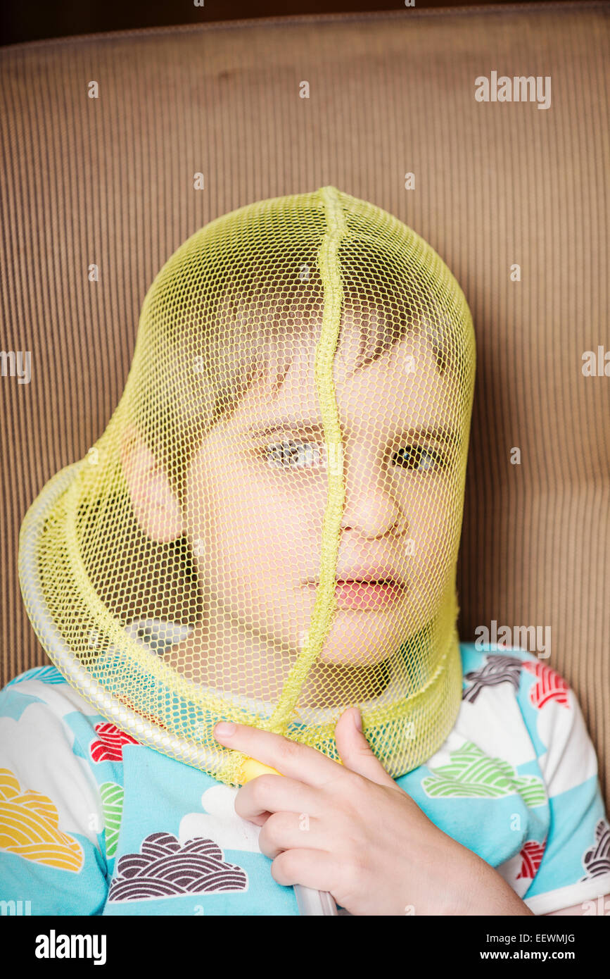 Portrait of girl with net covering her face. She looks troubled and ...