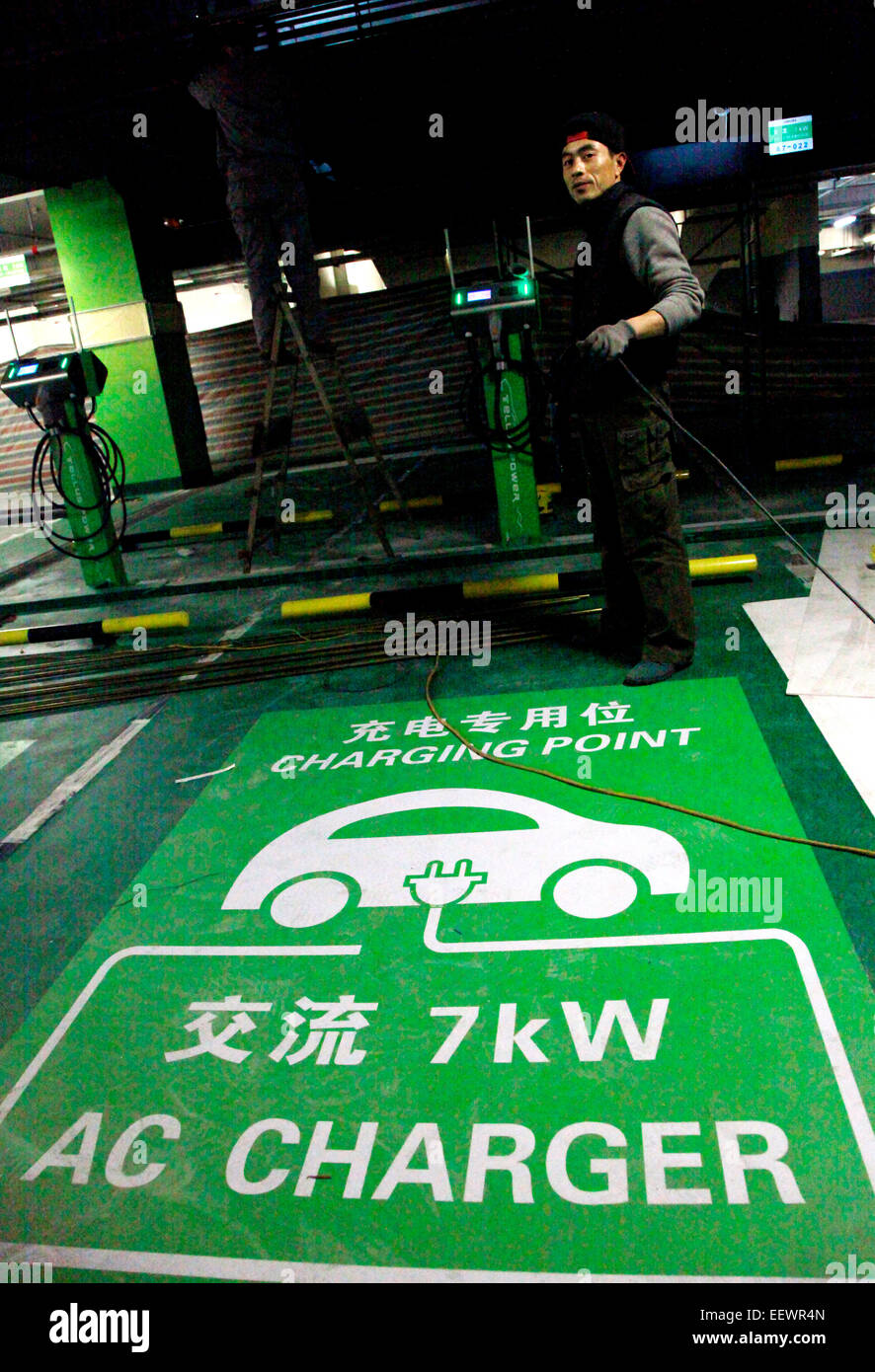 Beijing, China. 20th Jan, 2015. A staff tests a charging unit at a new ...