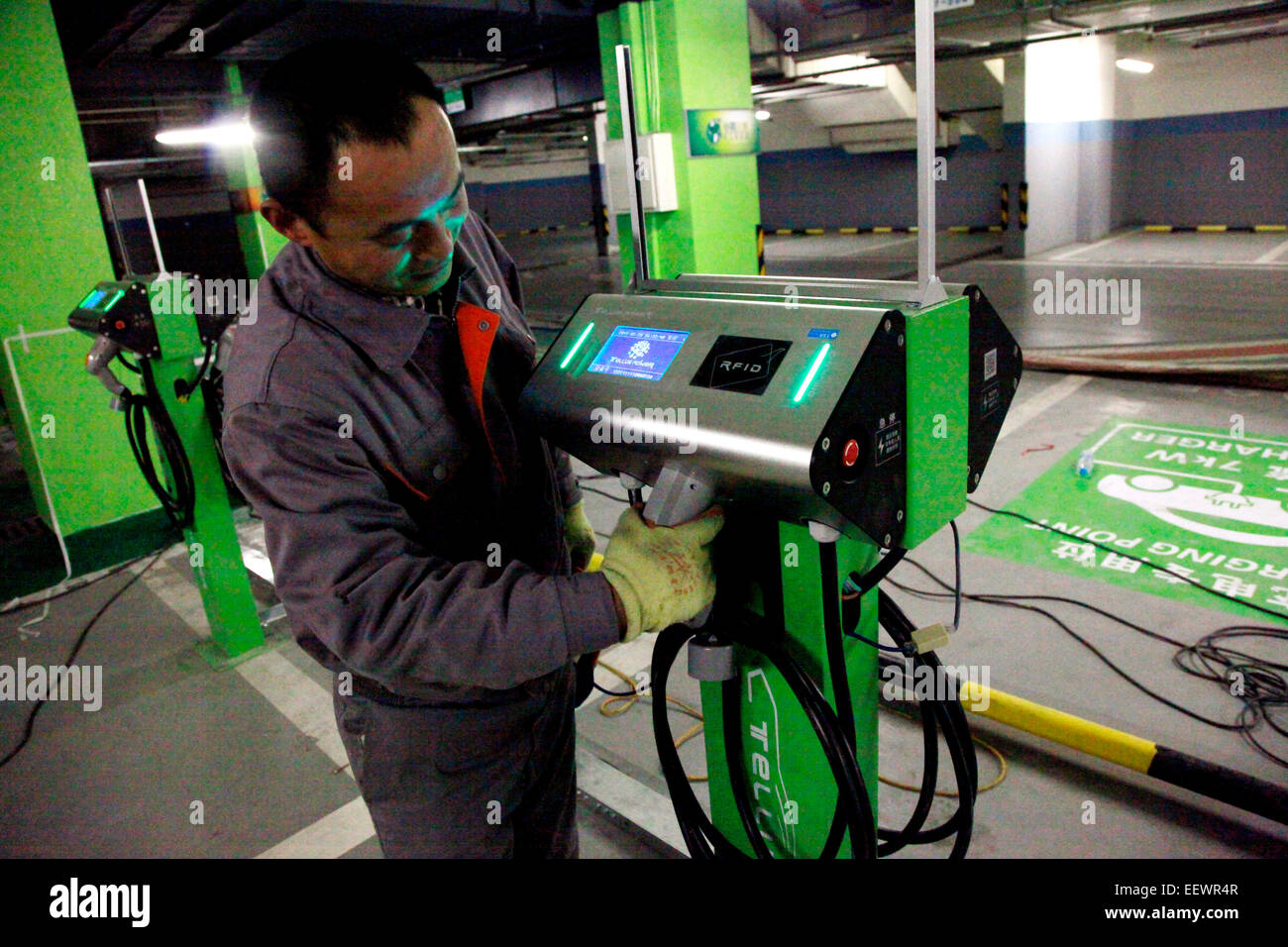 Beijing, China. 20th Jan, 2015. A staff tests a charging unit at a new ...