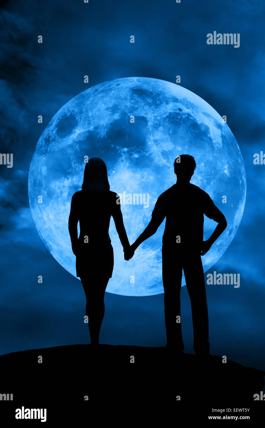 a couple hand in hand in front of a full moon Stock Photo - Alamy