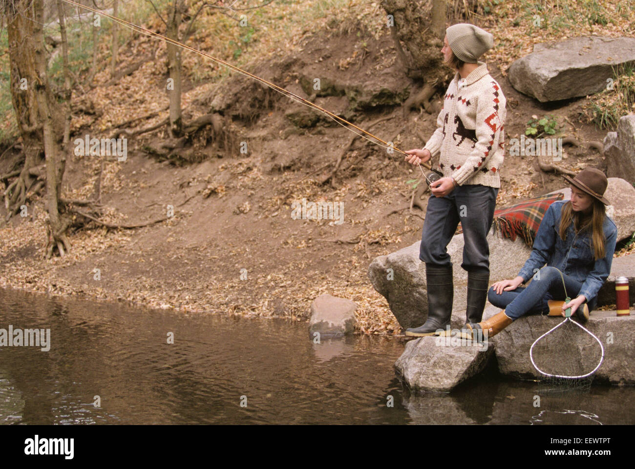 Young couple in a forest, fishing in a river Stock Photo - Alamy