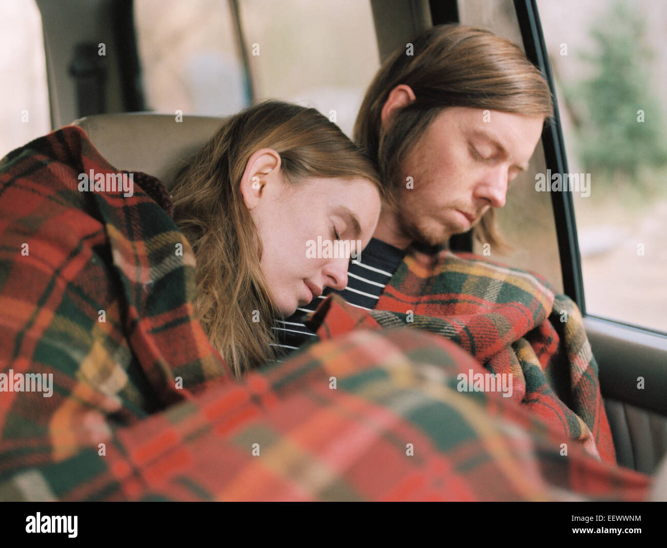 A couple taking a nap in their car, covered by a blanket Stock Photo ...