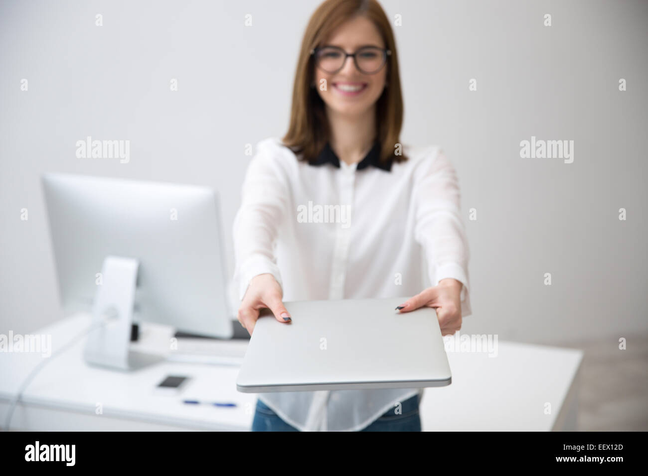 Happy businesswoman giving laptop on camera. Focus on laptop Stock ...