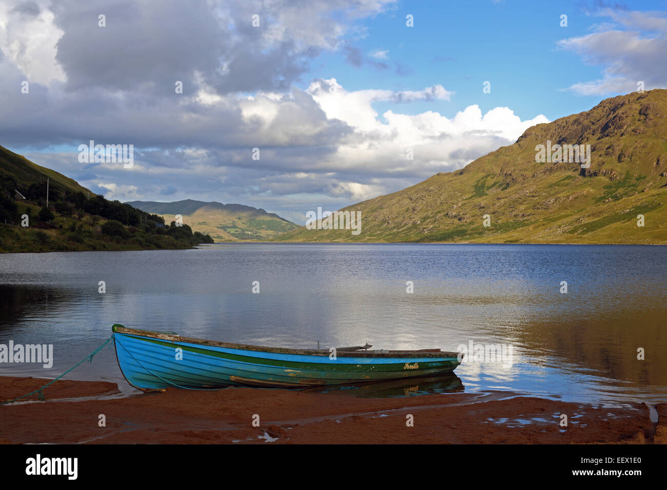 A traditional rowing boat lies astride a beautiful Irish lake on a ...