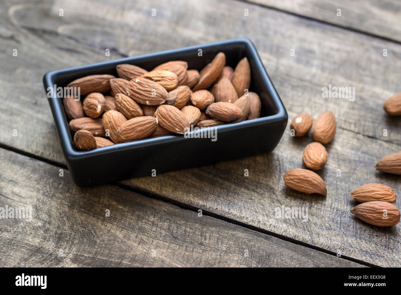 almonds in bowl on grained wood background, close up Stock Photo - Alamy