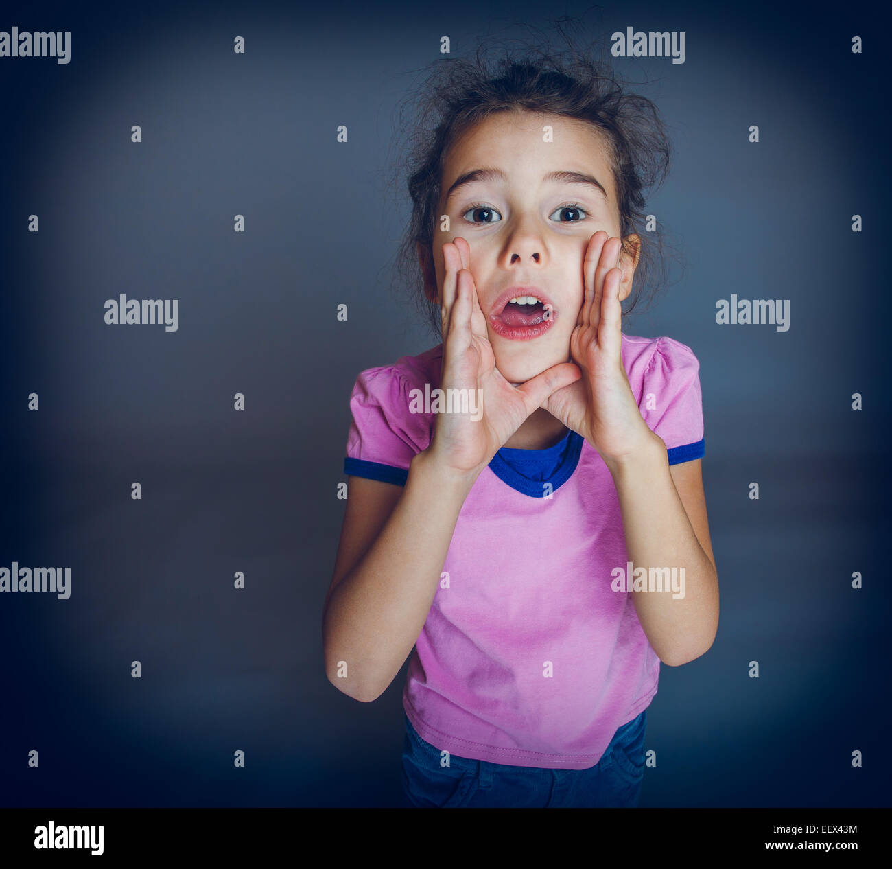 teen girl opened her mouth calls on a gray background cross proc Stock ...