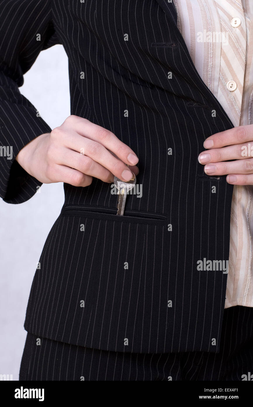 Businesswoman putting a key into her pocket Stock Photo - Alamy