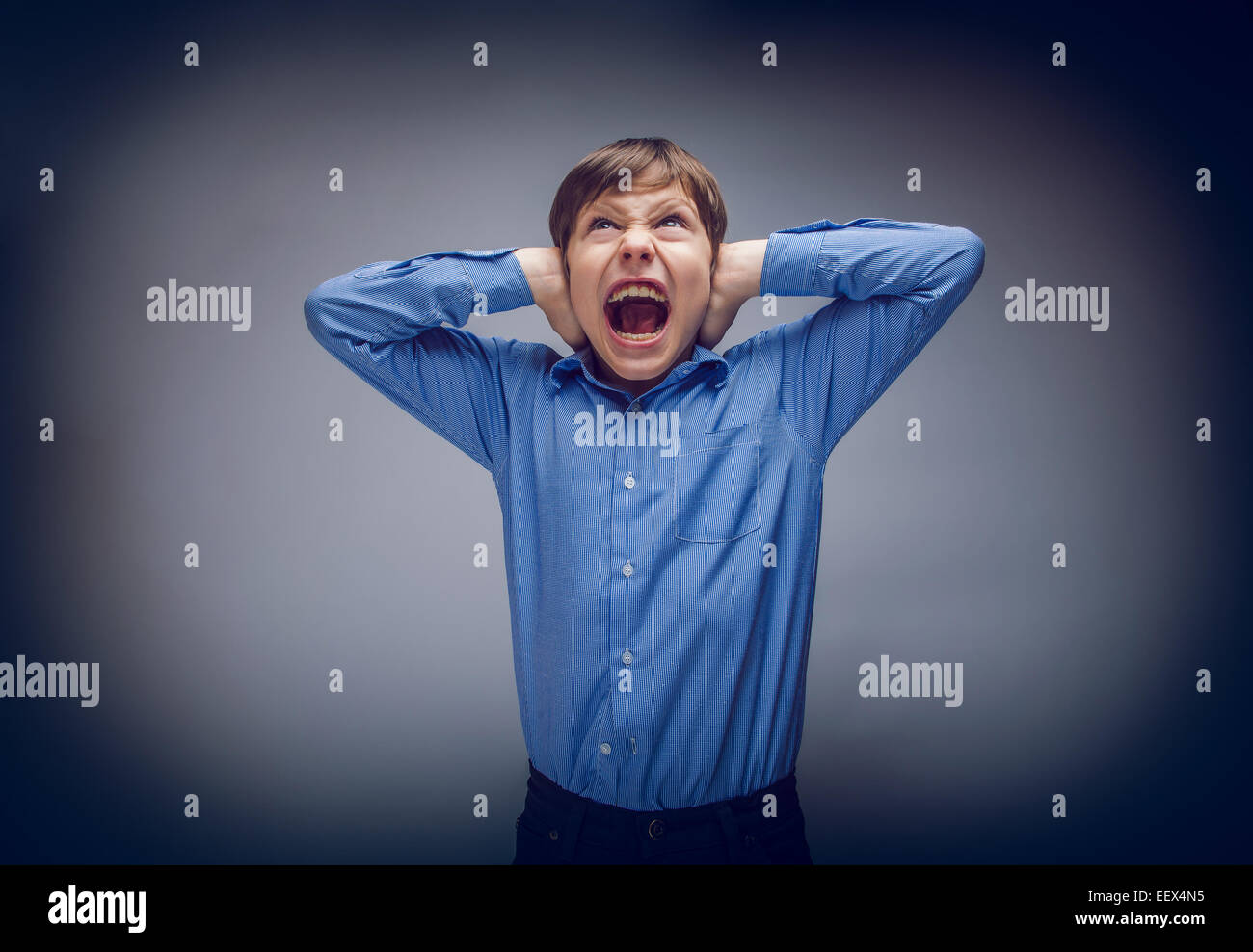 teenager boy shouts shut his ears opened mouth on Stock Photo - Alamy