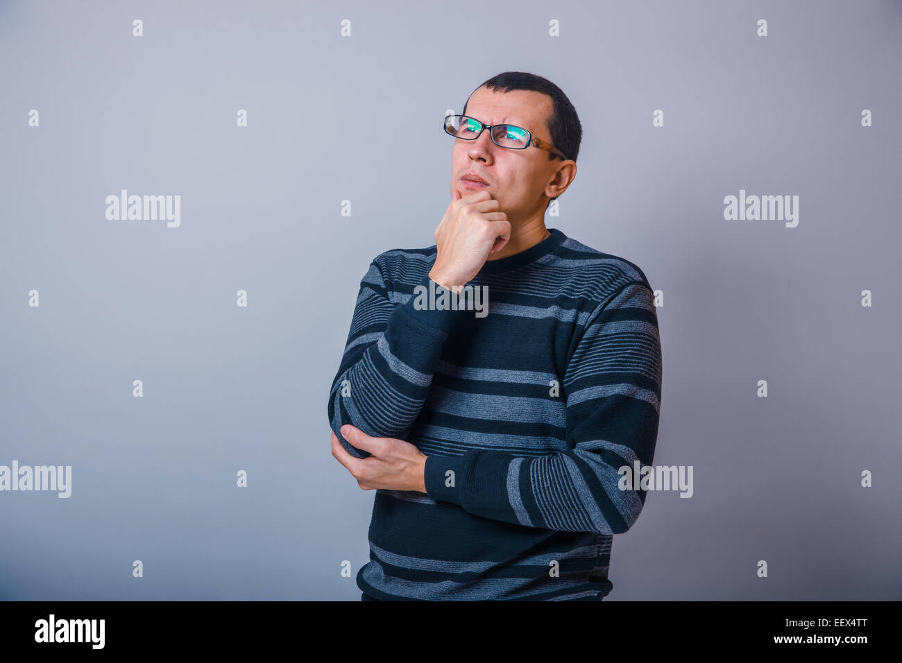 European-looking man years in glasses, thinking Stock Photo - Alamy