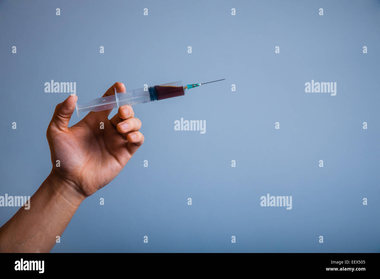 hand holding syringe with drug addict on a gray background Stock Photo ...