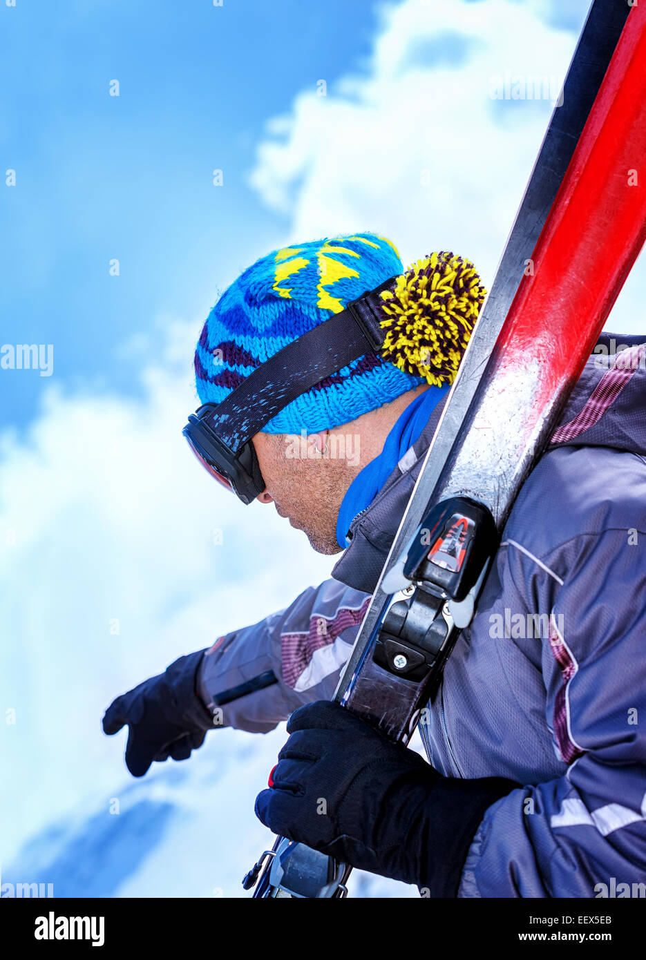 Handsome ski trainer shows the way for the descent from the mountain ...