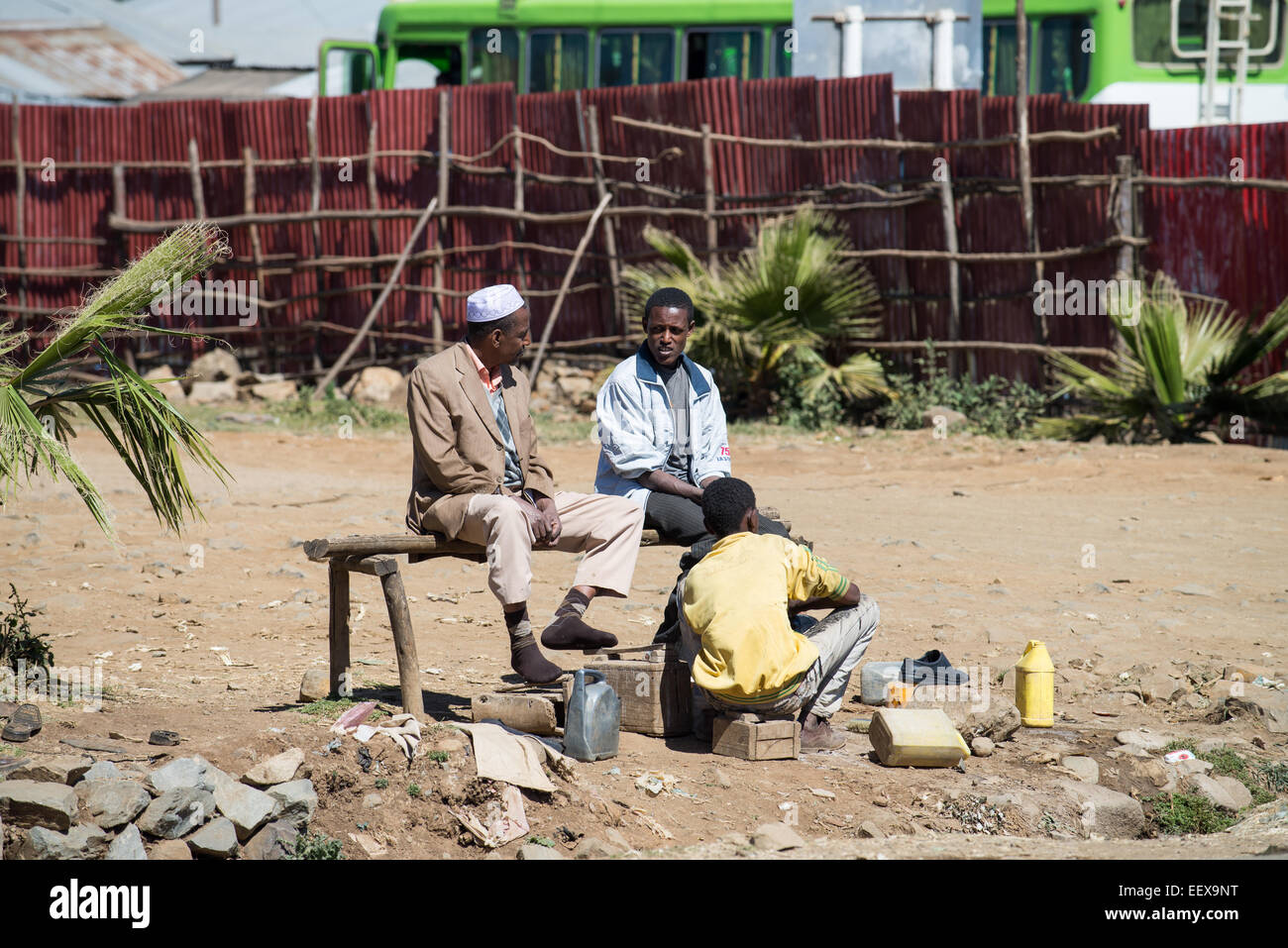 Shoe shine, man cleaning and polishing shoes of people sitting on ...