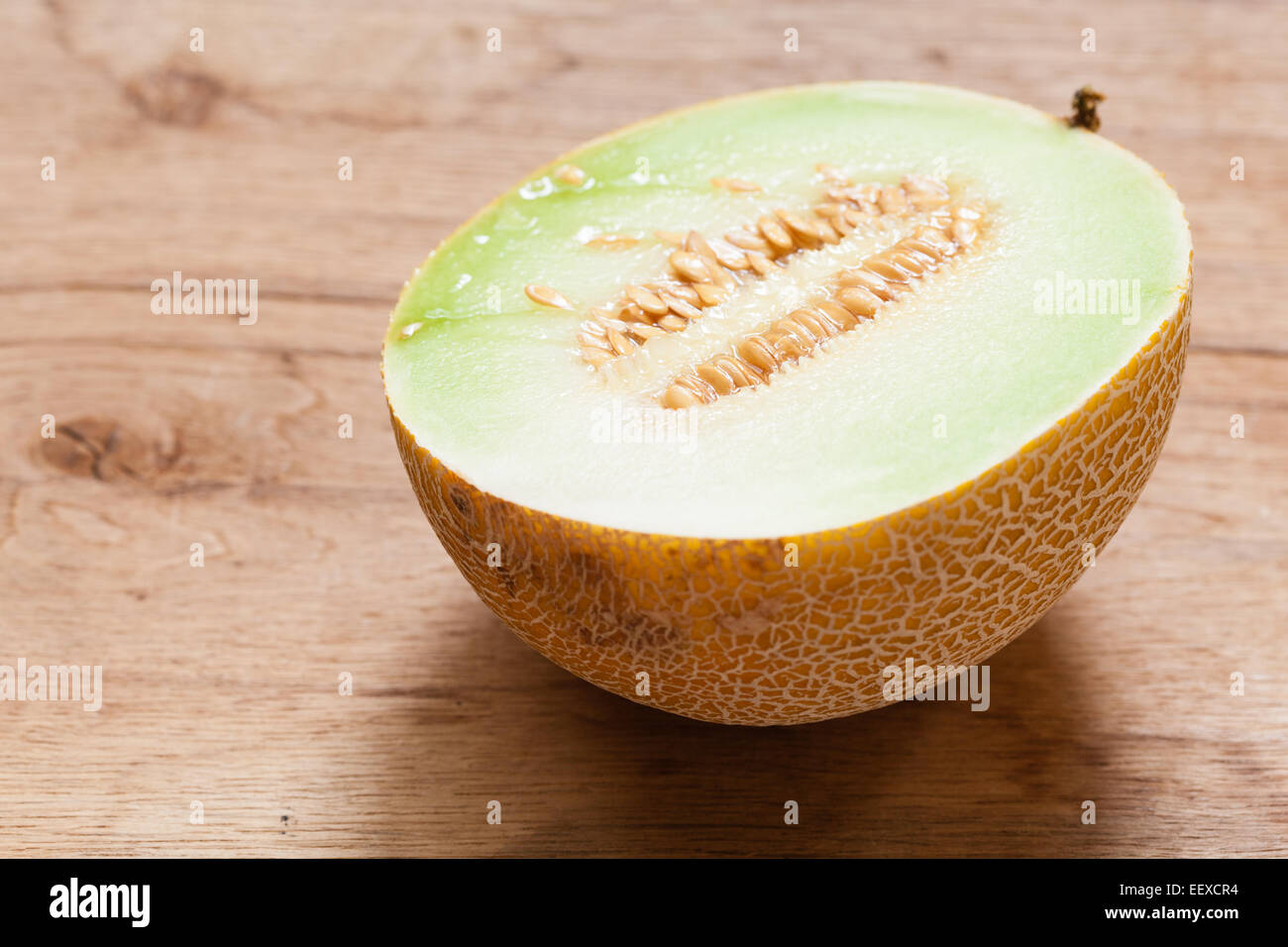 Closeup of melon with pips on wooden table. Fruit, diet and healthy ...
