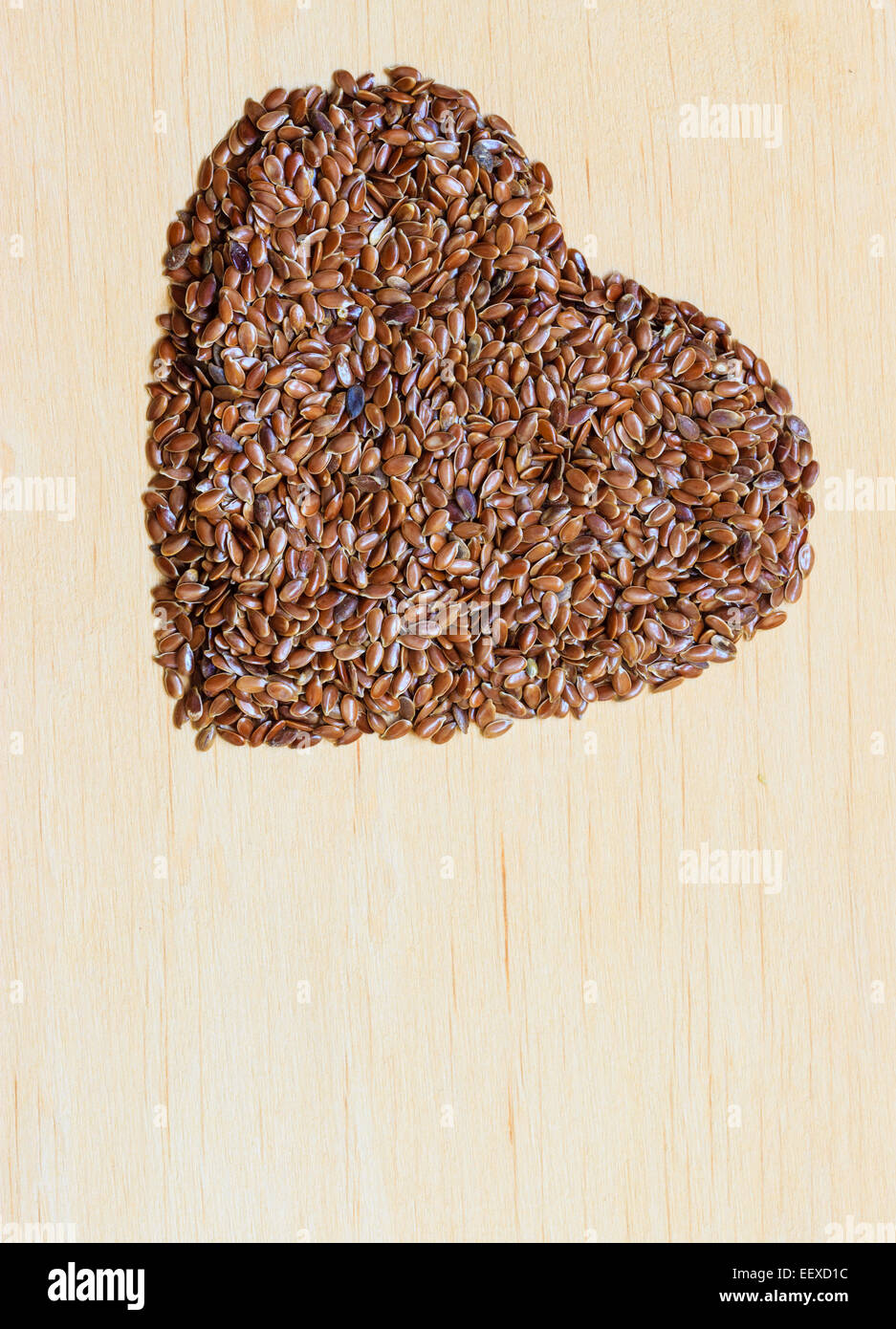 Diet healthcare concept. Raw flax seeds linseed heart shaped on wooden background. Healthy food ...