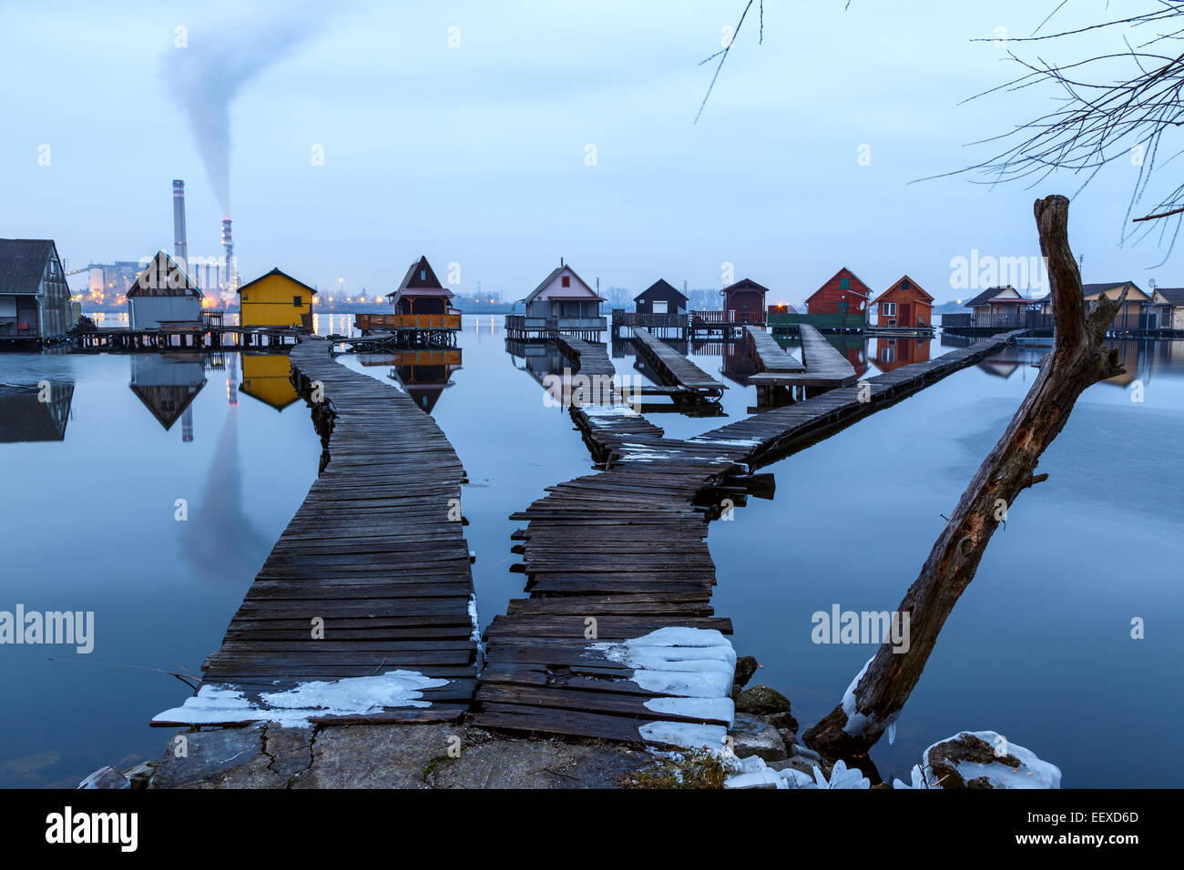 Sunset lake Bokod with pier and fishing wooden cottages, power plant in ...