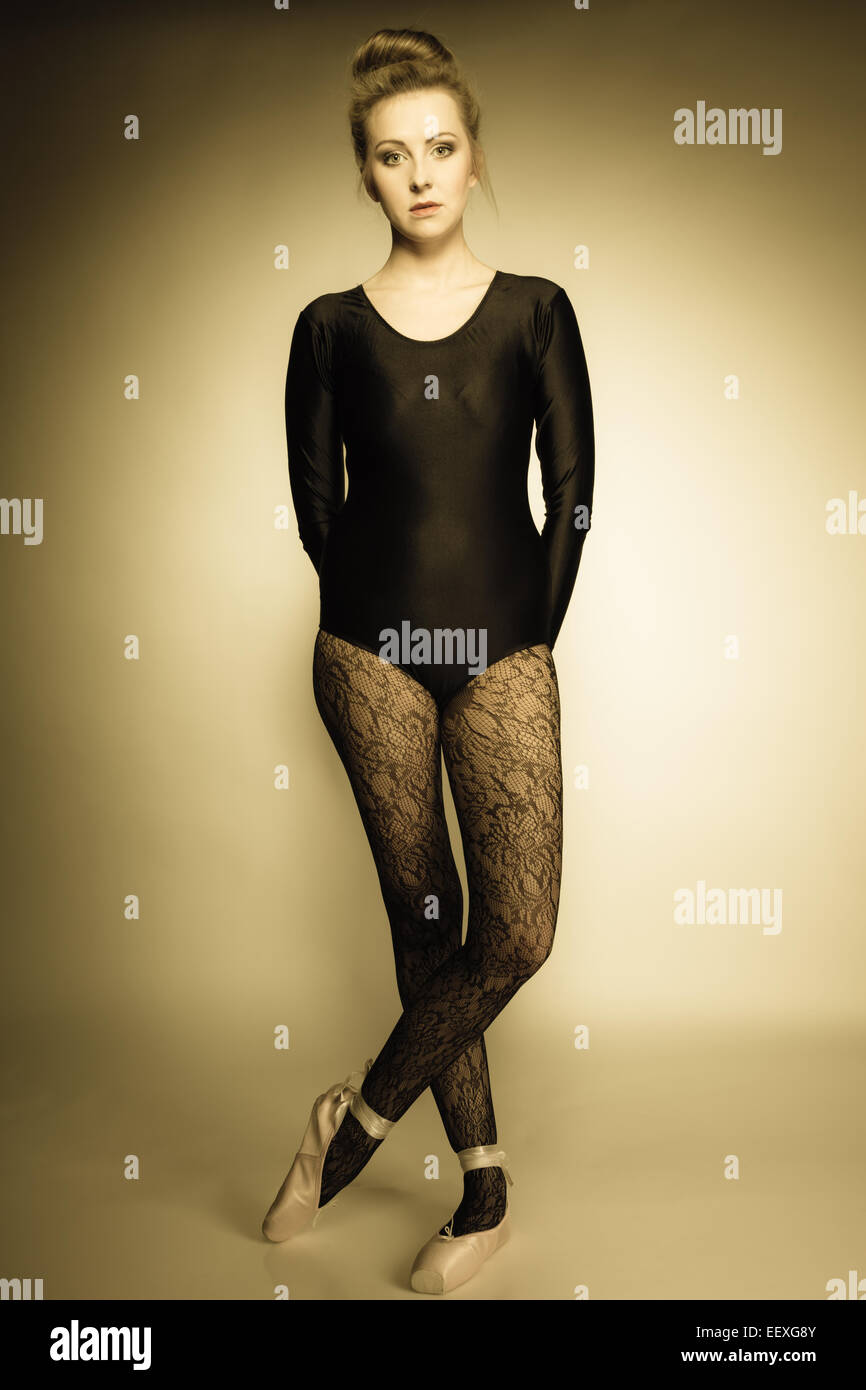 Graceful beautiful woman ballet dancer full length studio shot sepia ...