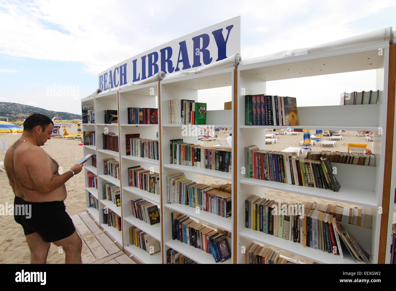 People look for and read books at the first ever free beach library ...