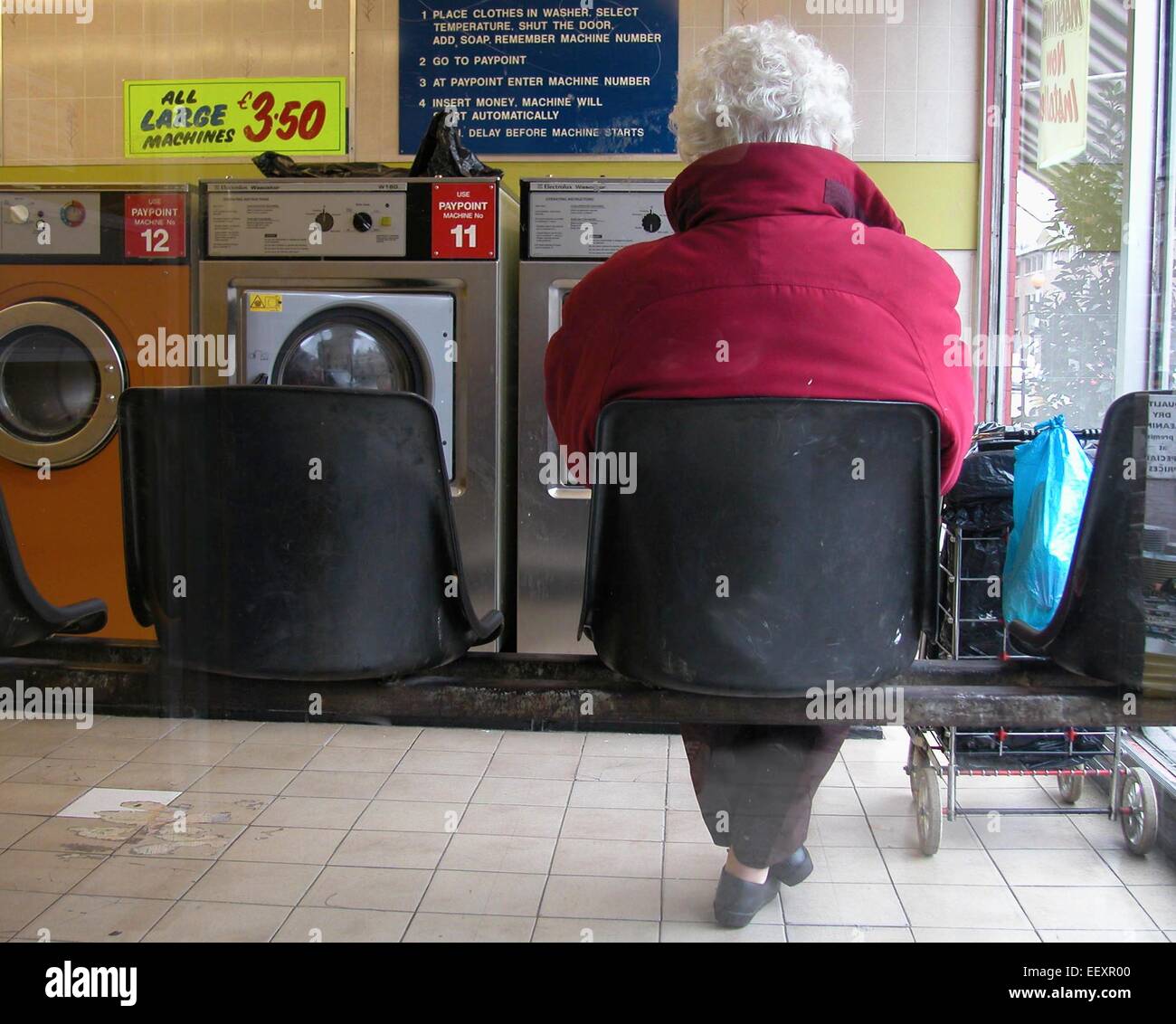 Dirty washing old age pensioner in Laundrette watching laundry, London ...