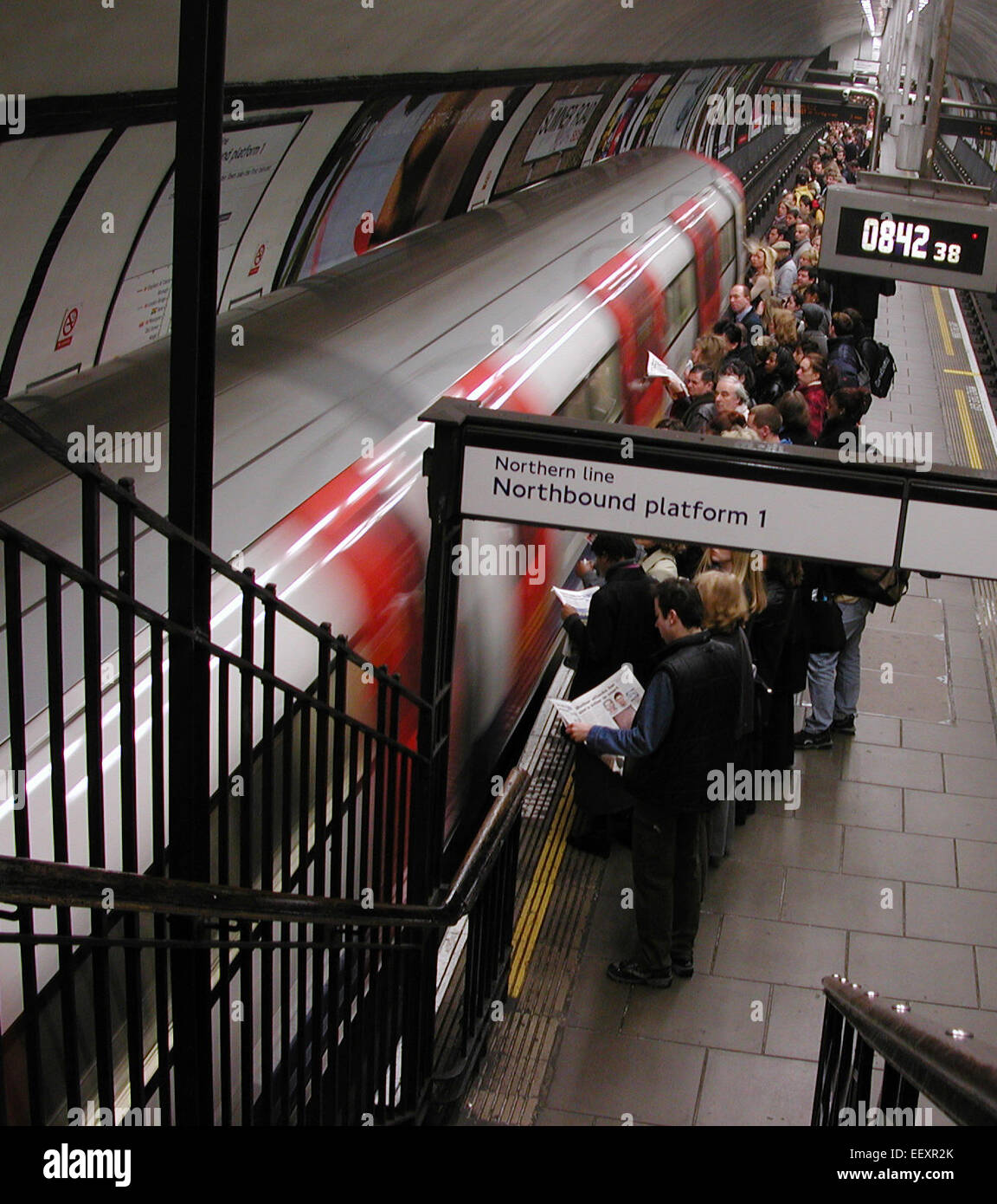 Train enters station as commuters wait for tube train on London ...