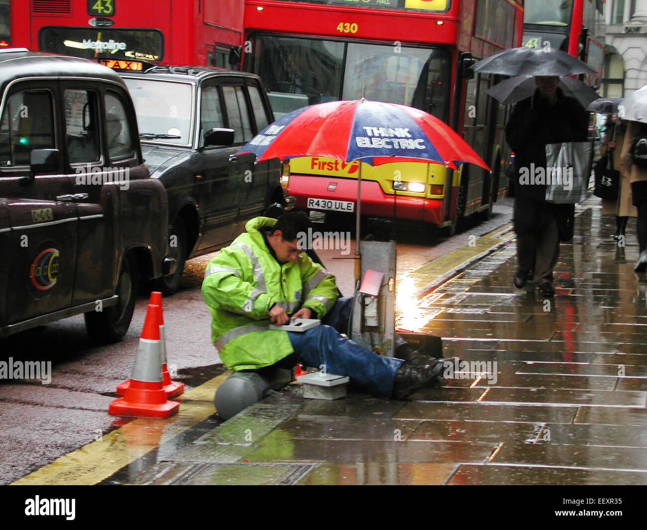 Electricity worker sheltering from rain during maintenance work in ...