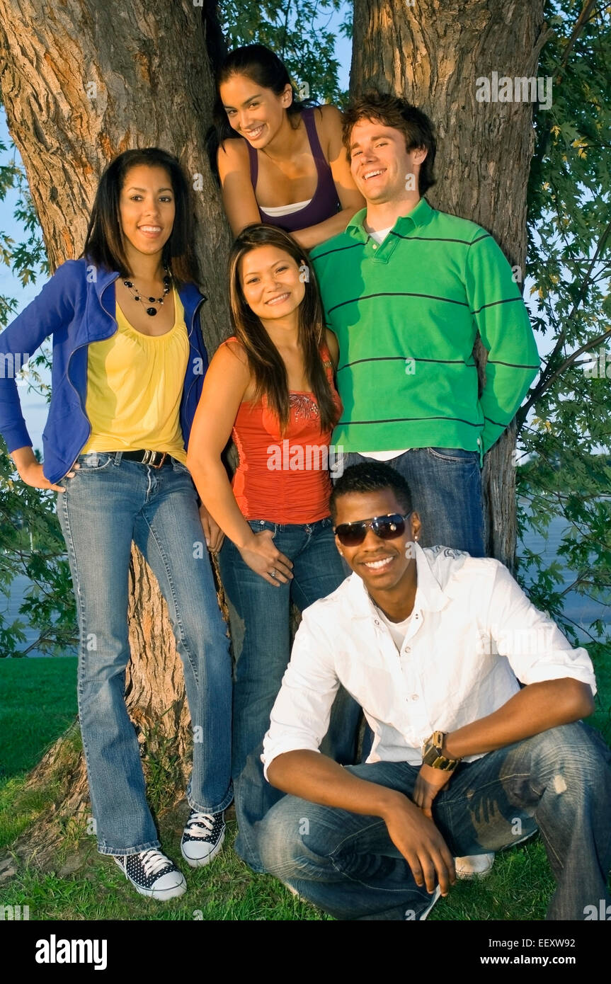 Five friends outdoors by a tree Stock Photo - Alamy