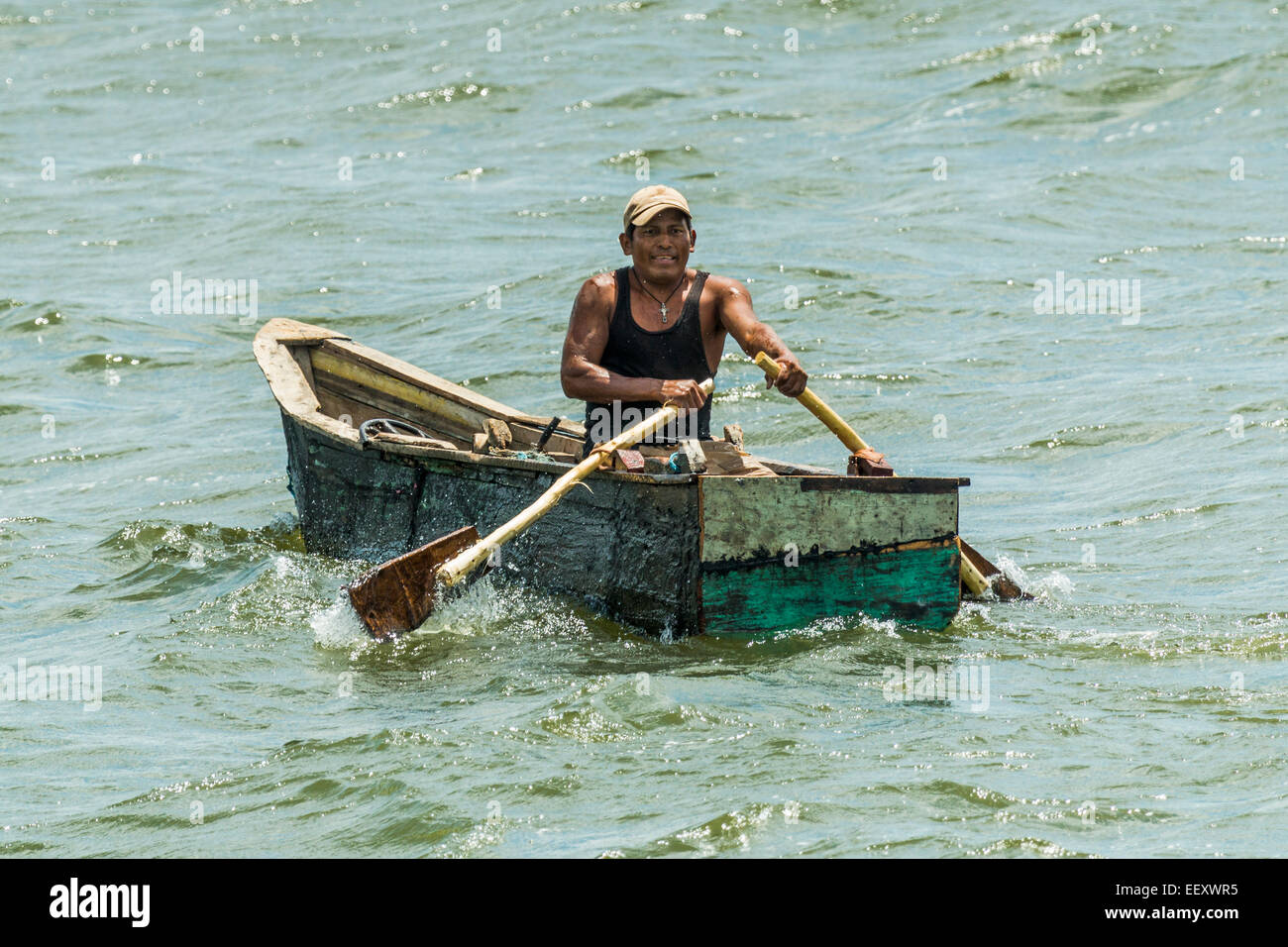 Man rowing small homemade boat offshore of Myogalpa and popular Omotepe ...