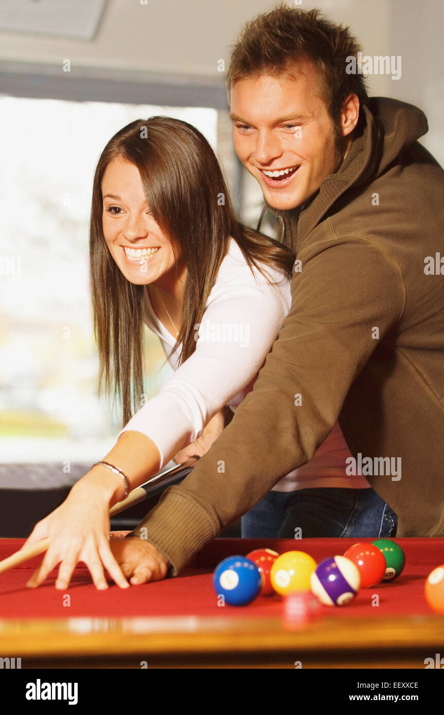 Man showing woman how to play pool Stock Photo - Alamy