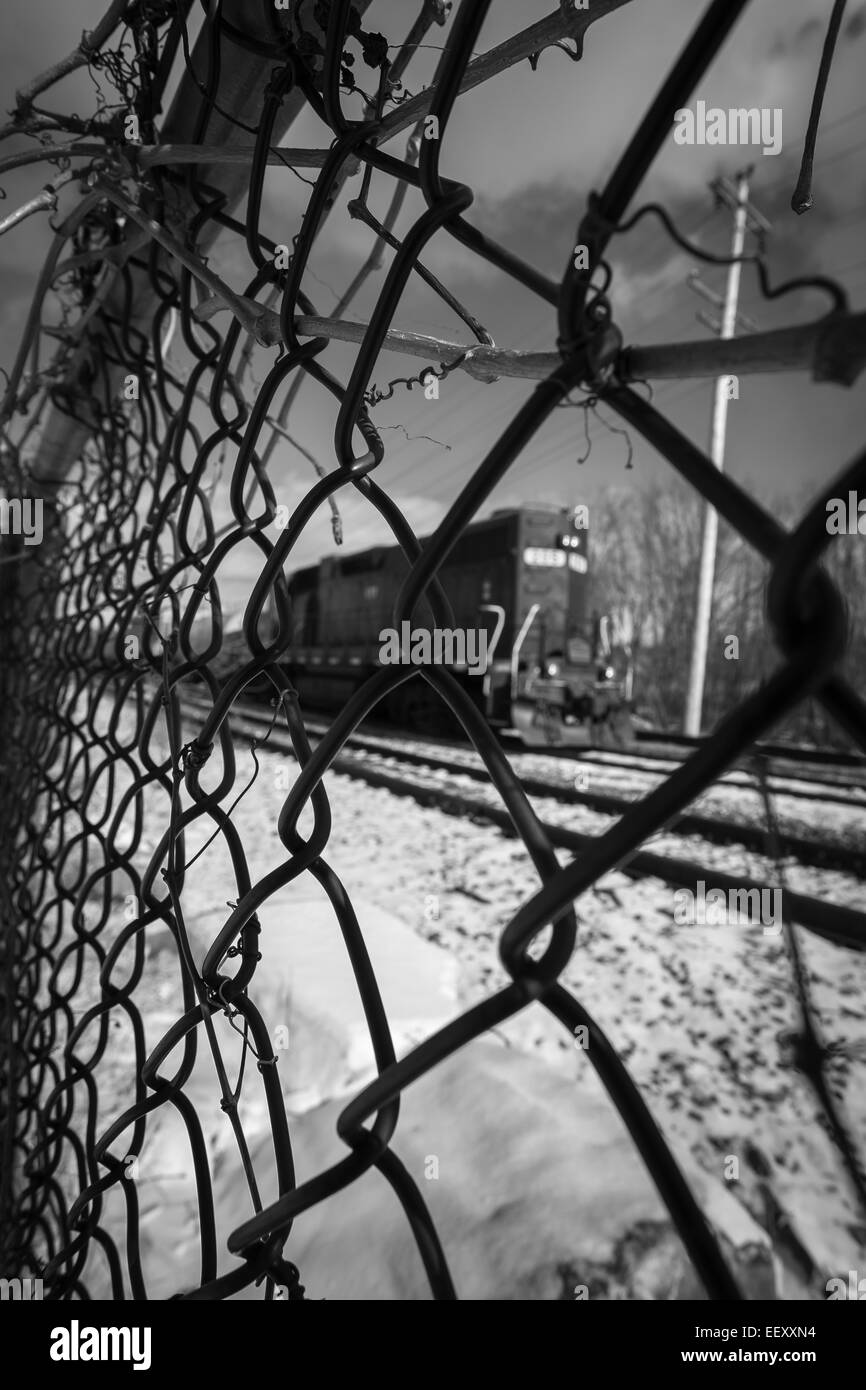 Looking at a train through a chain link fence Stock Photo - Alamy