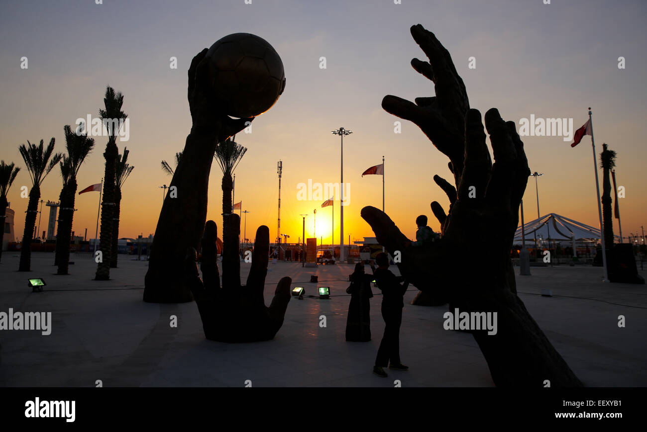 Spectators look at a sculpture of hands with a ball in front of the ...