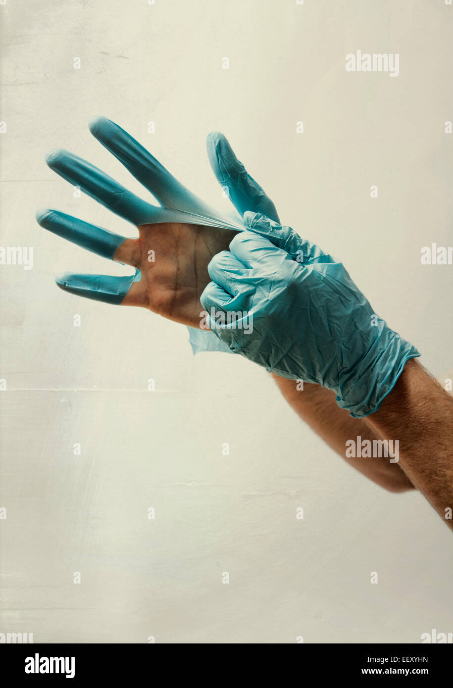 Hands with Ripped Blue Gloves Stock Photo - Alamy