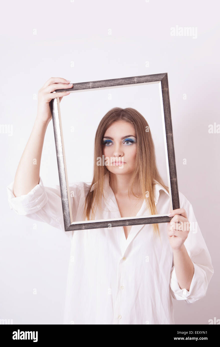 Sad beautiful girl holding a frame in his hands Stock Photo - Alamy