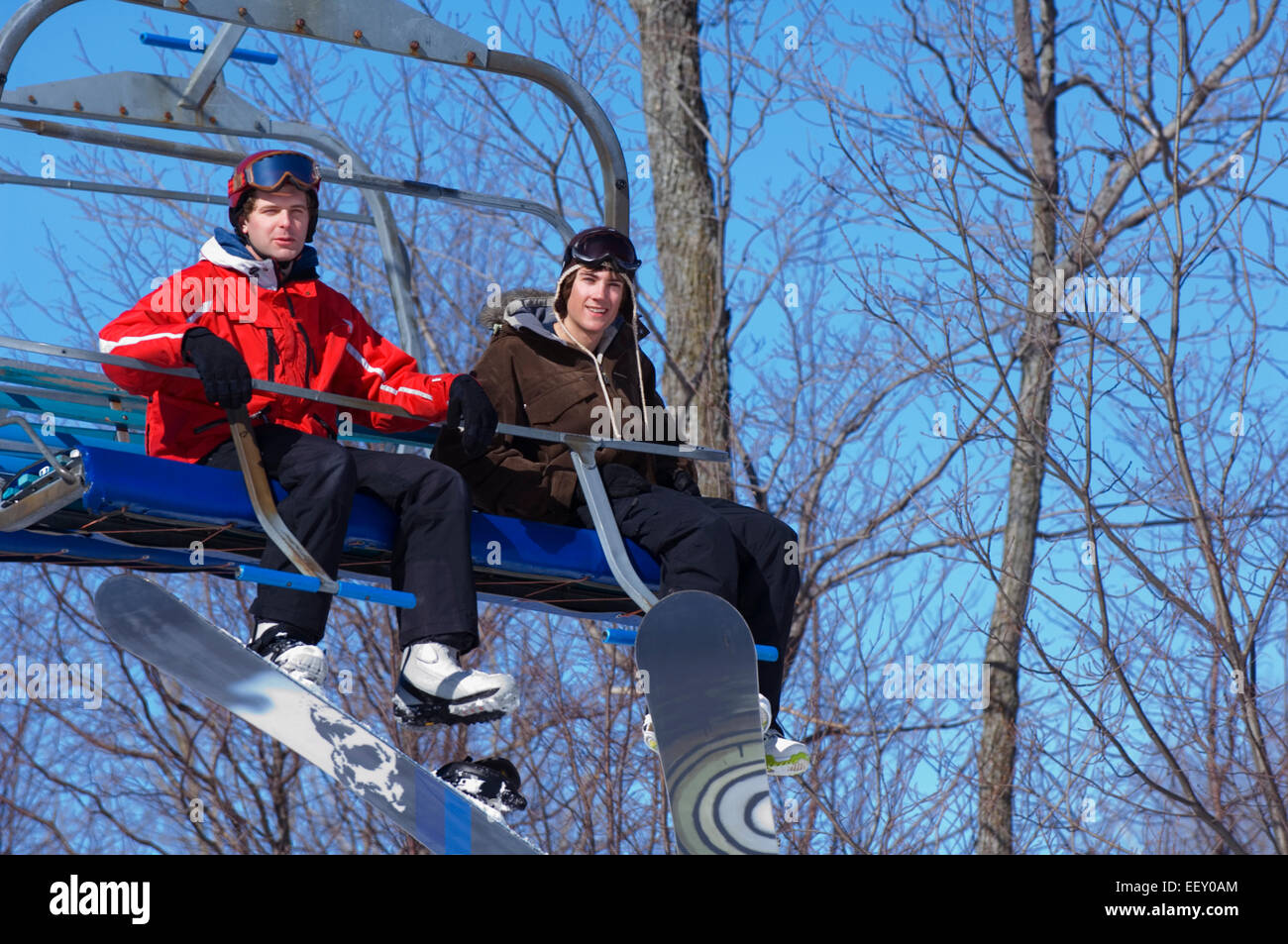 Snowboarding friends on a chairlift Stock Photo - Alamy