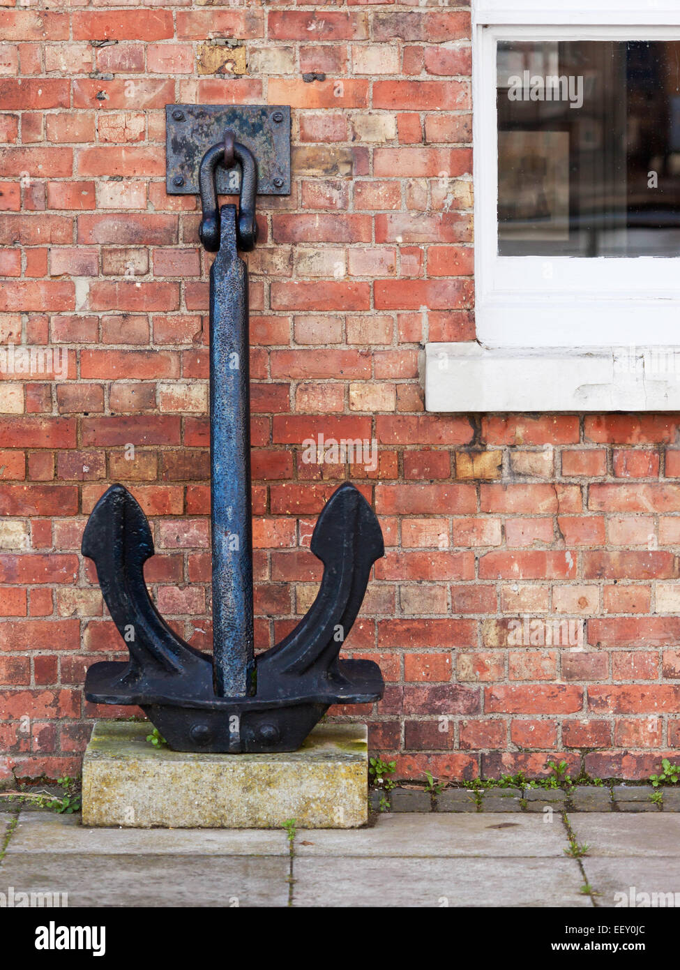 Old black painted anchor resting next to a wall Stock Photo - Alamy