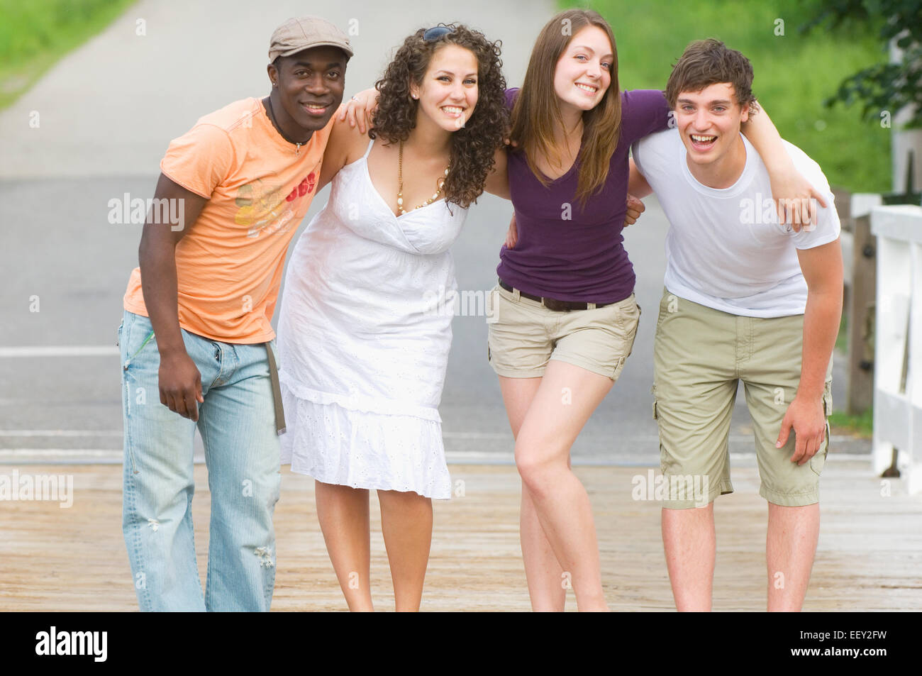 Four friends standing on a bridge Stock Photo - Alamy